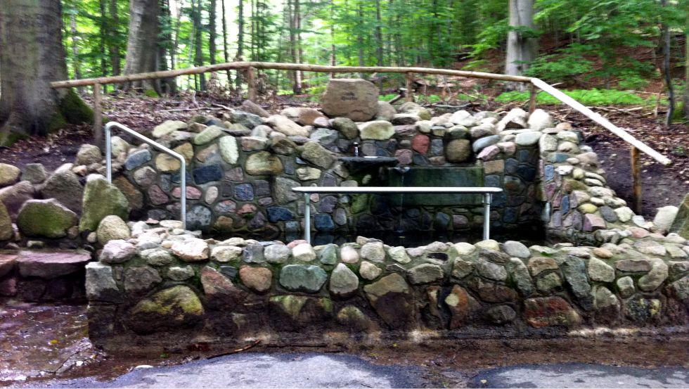 Natural stone Kneipp basin at the house lake